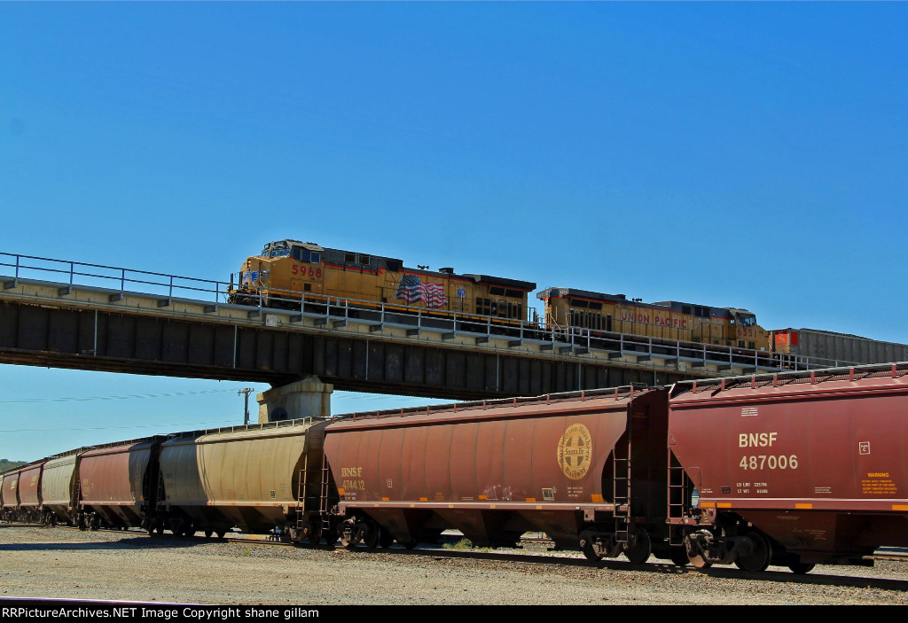 UP 5968 heads EB over a Nb bnsf grain train.